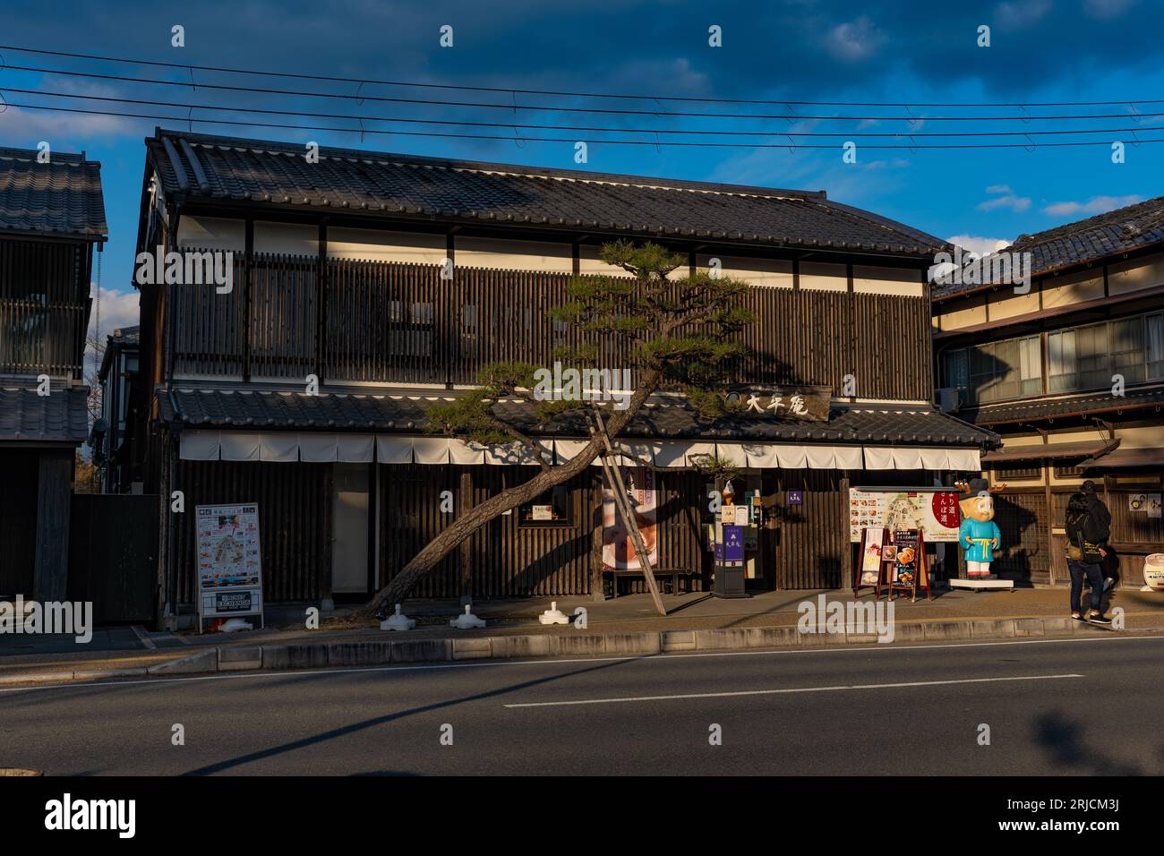 An urban street scene featuring a row of quaint wooden buildings with ...