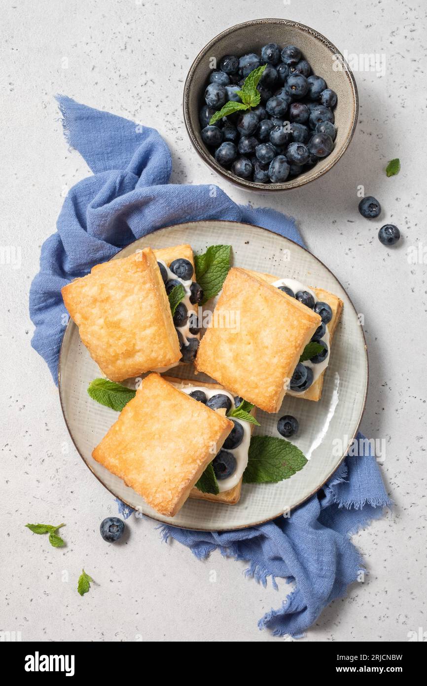 Stuffed homemade puff cookies with whipped cream and blueberries Stock ...