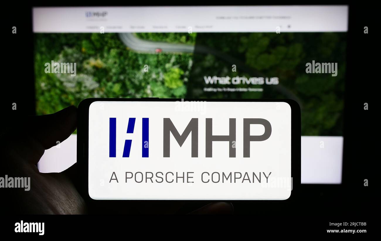 Person holding mobile phone with logo of company MHP Management- und IT ...