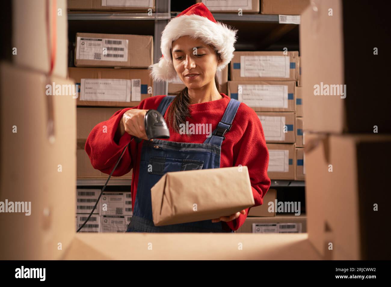 Manager scanning barcode on delivery parcel. Female worker scan barcode of cardboard packages ...