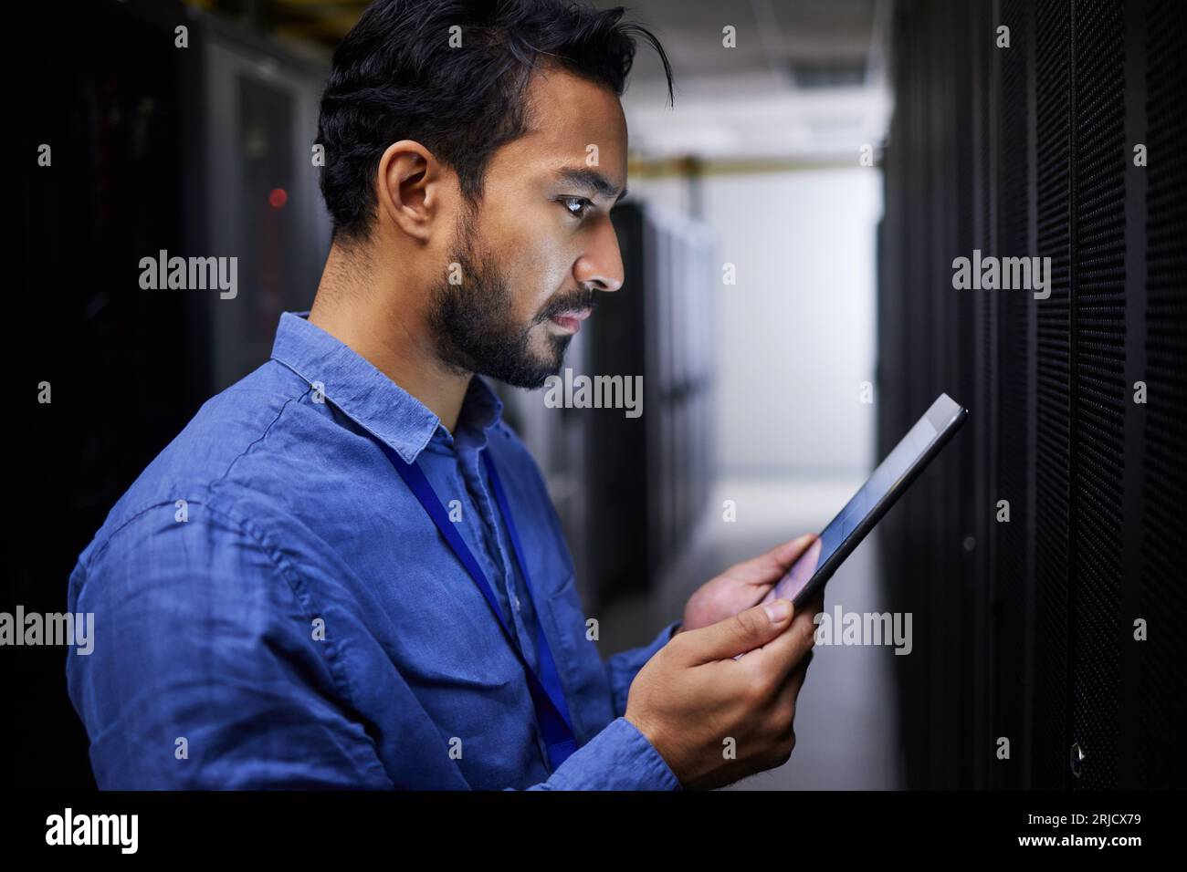 Tablet, man and reading in server room of technician programming at night. Information ...