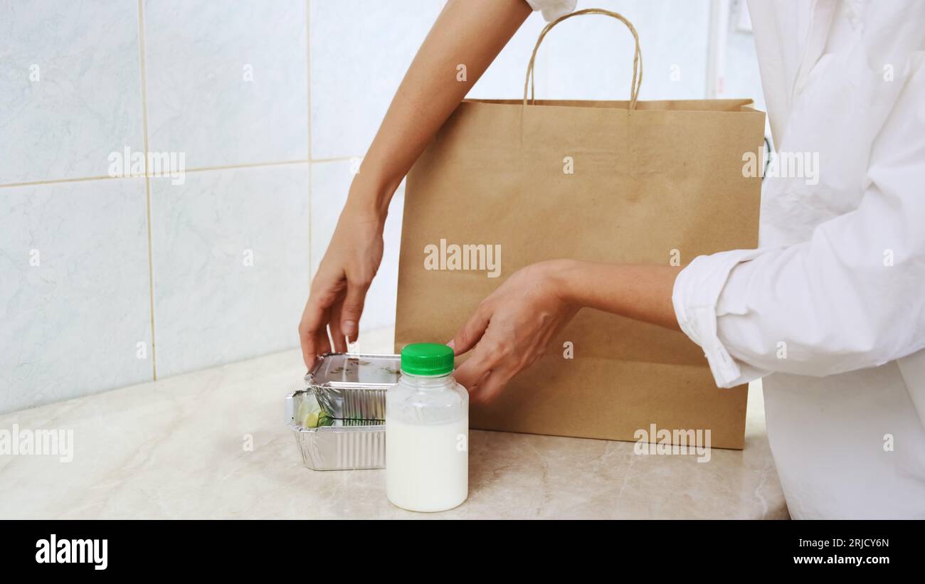 Woman pack ready meal lunch for clients. Delivery of balanced diet food ...