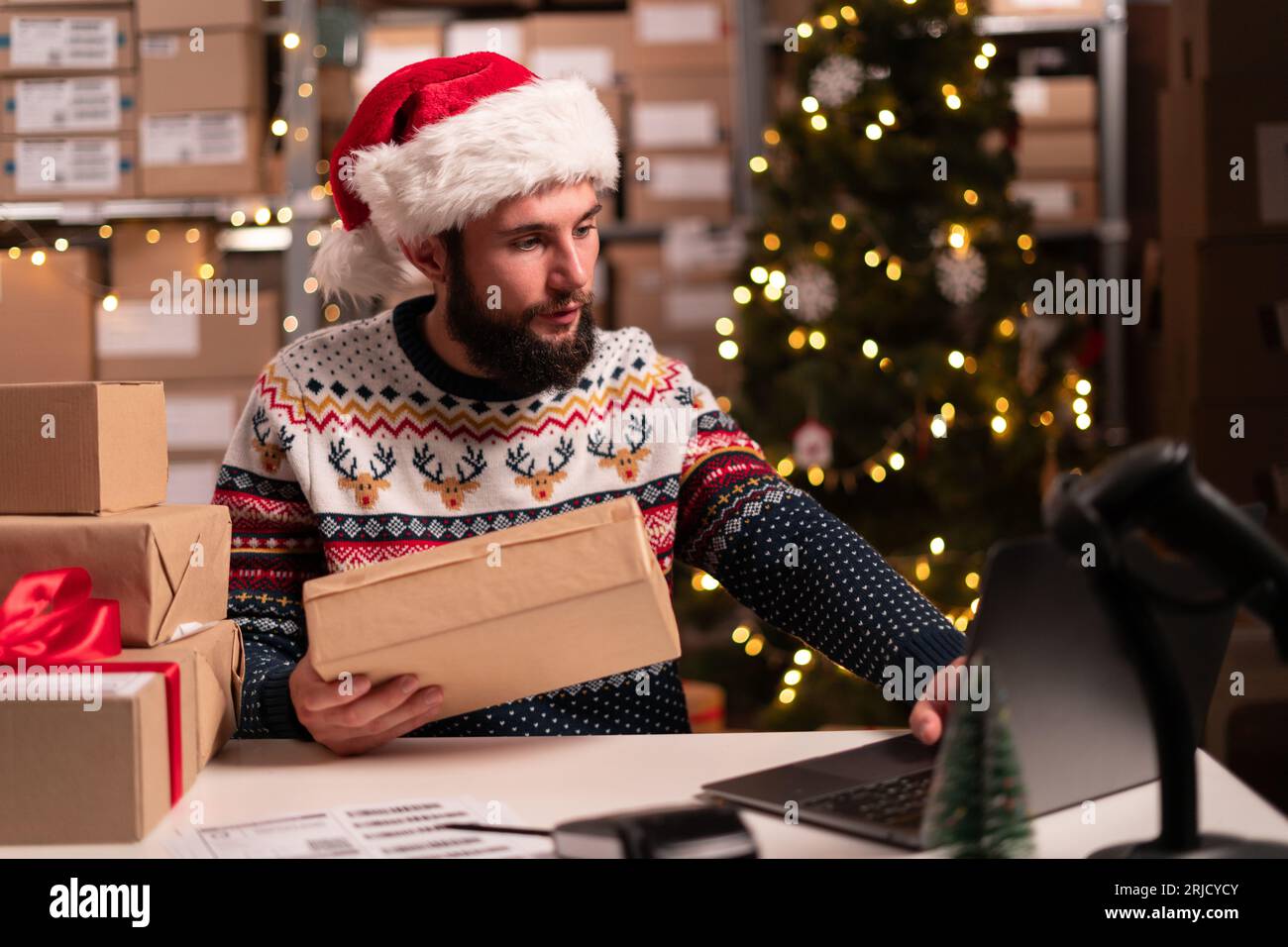 Warehouse worker packing Christmas gift boxes for clients small ...