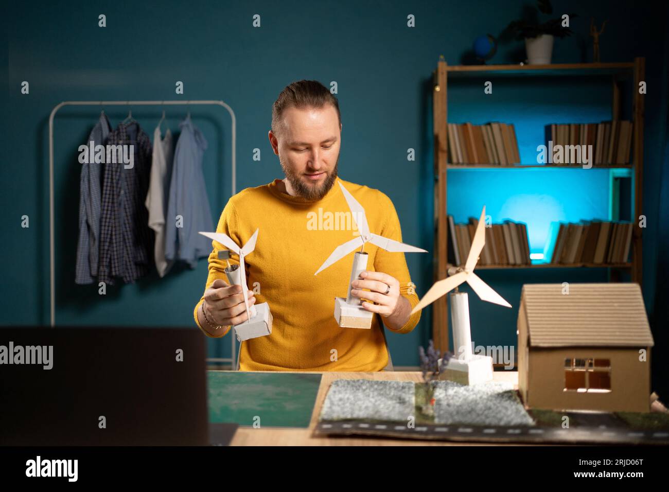 A man creating a creative 3d wind power project at home in the evening ...