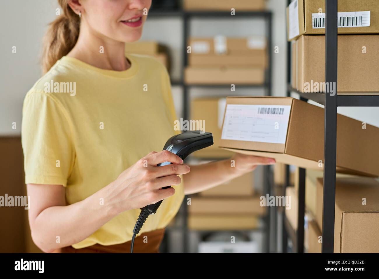 Cropped shot of young female worker of warehouse scanning qr codes on ...