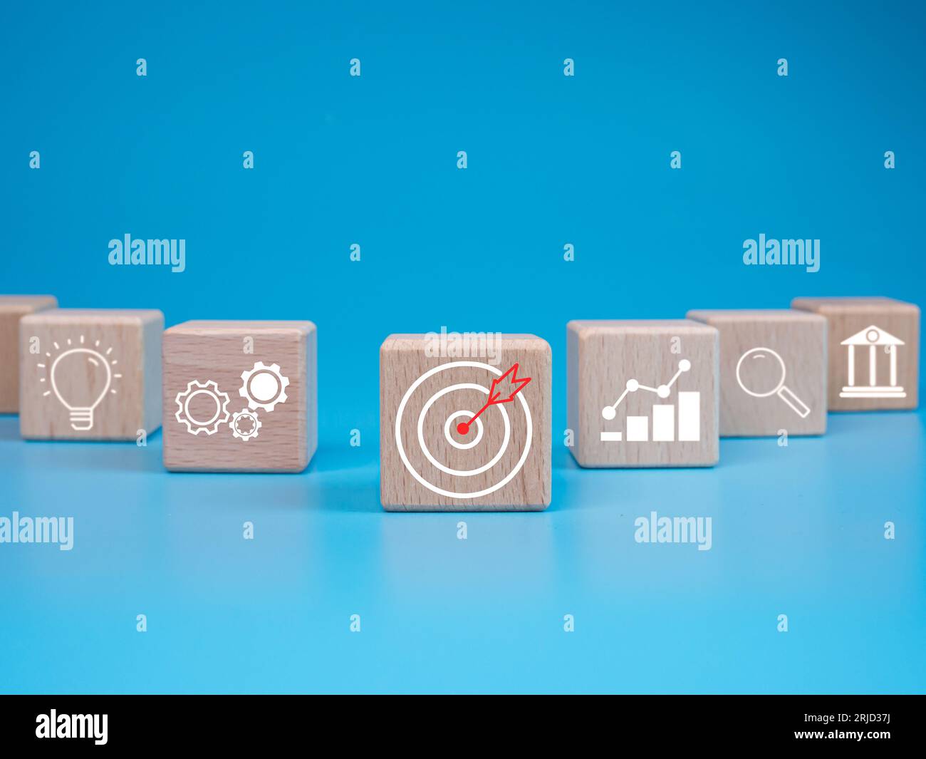 wooden block which prints a target icon and business symbol on light ...