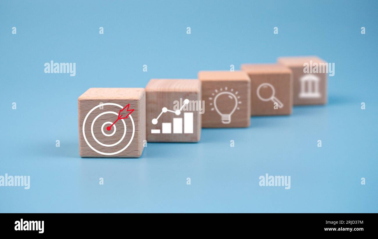 wooden block which prints a target icon and business symbol on light ...