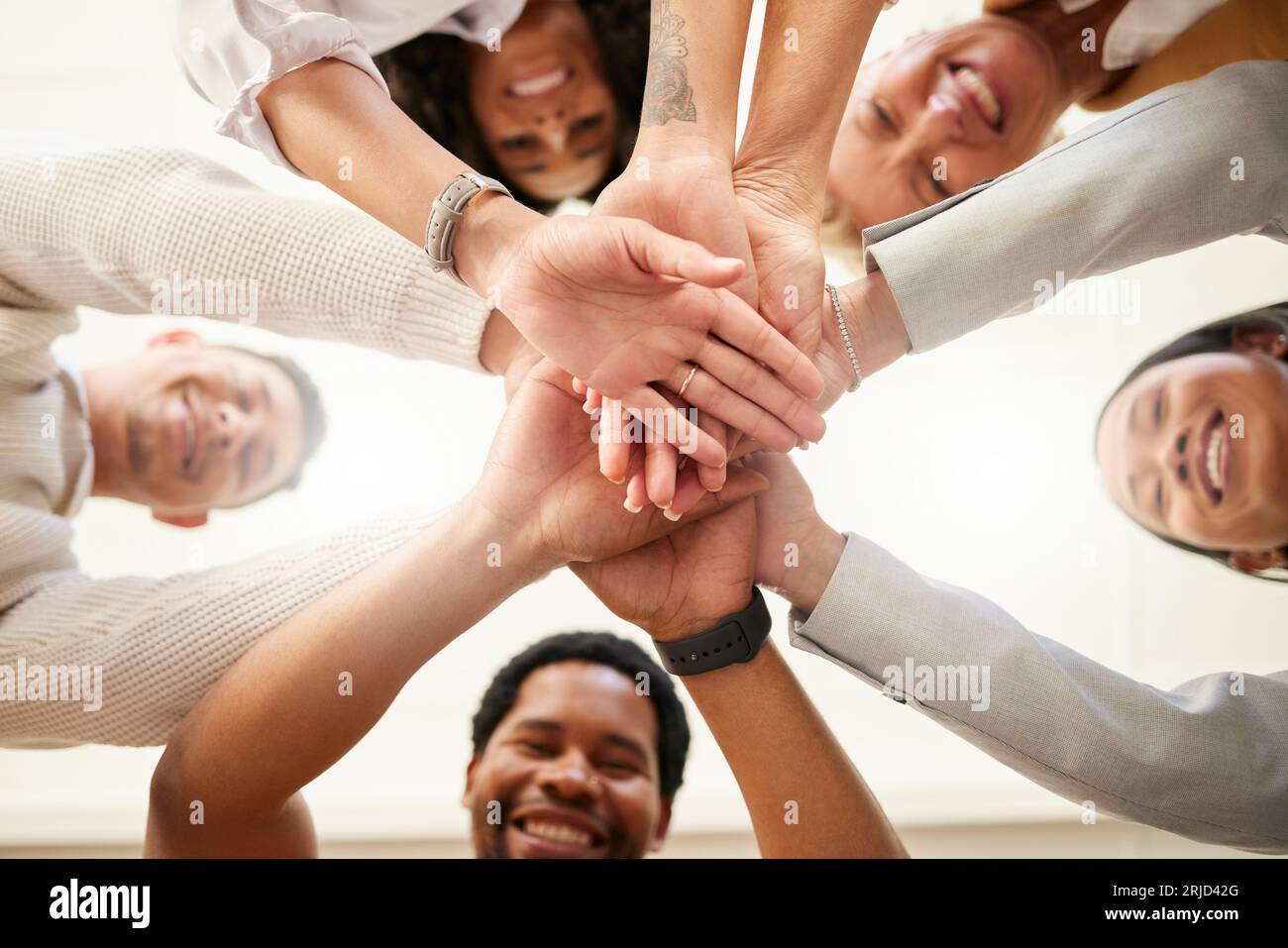Office, team building and hands together from below in huddle for teamwork, collaboration and ...
