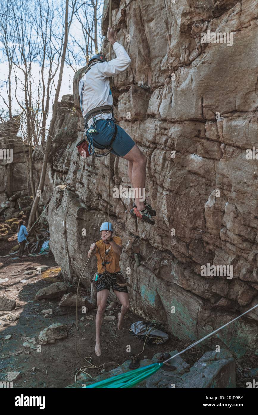 Two fit men in Western Pennsylvania performing top rope rock climbing ...