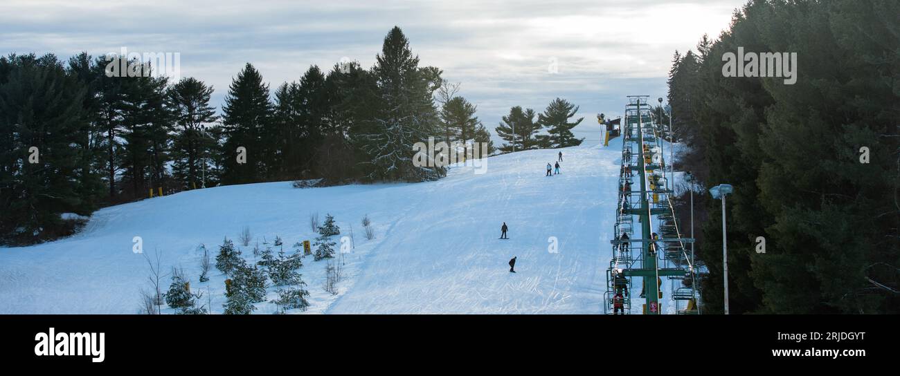 A scenic winter landscape featuring a ski slope with multiple people ...