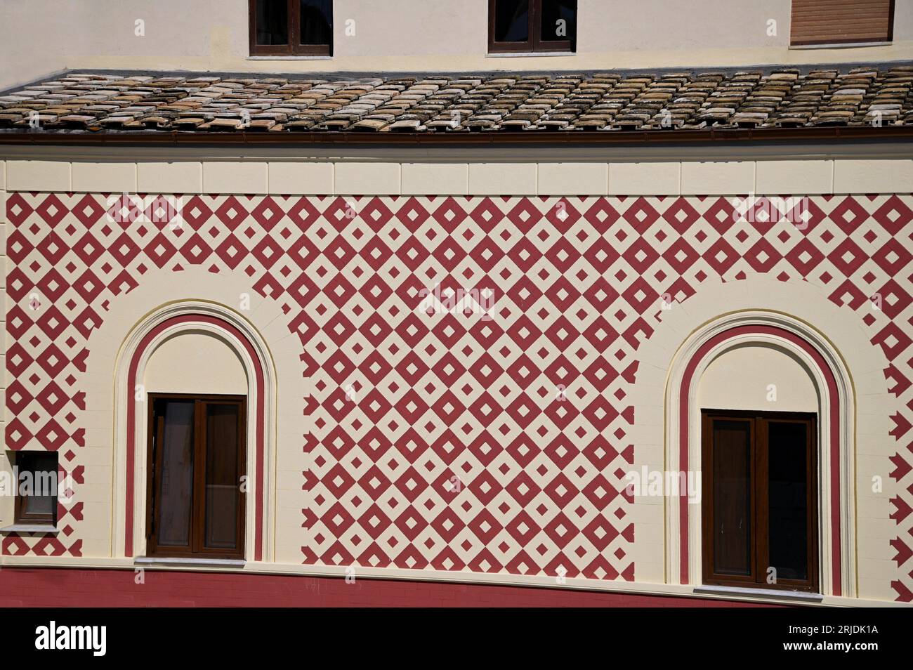 Sicilian building facade with a ceramic tiles wall and arched windows ...