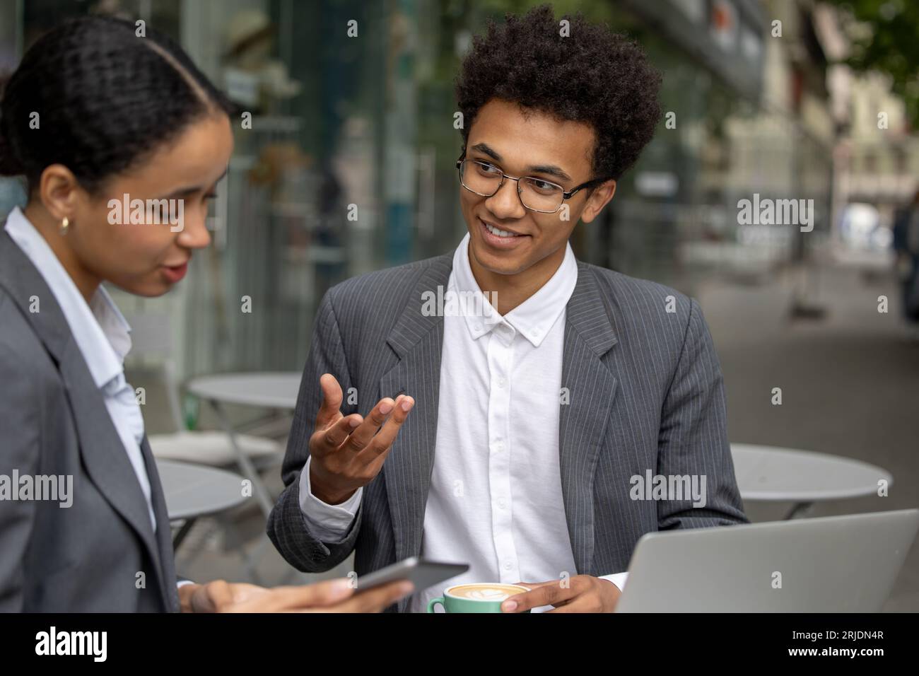 Two business people discussing something and looking involved Stock ...