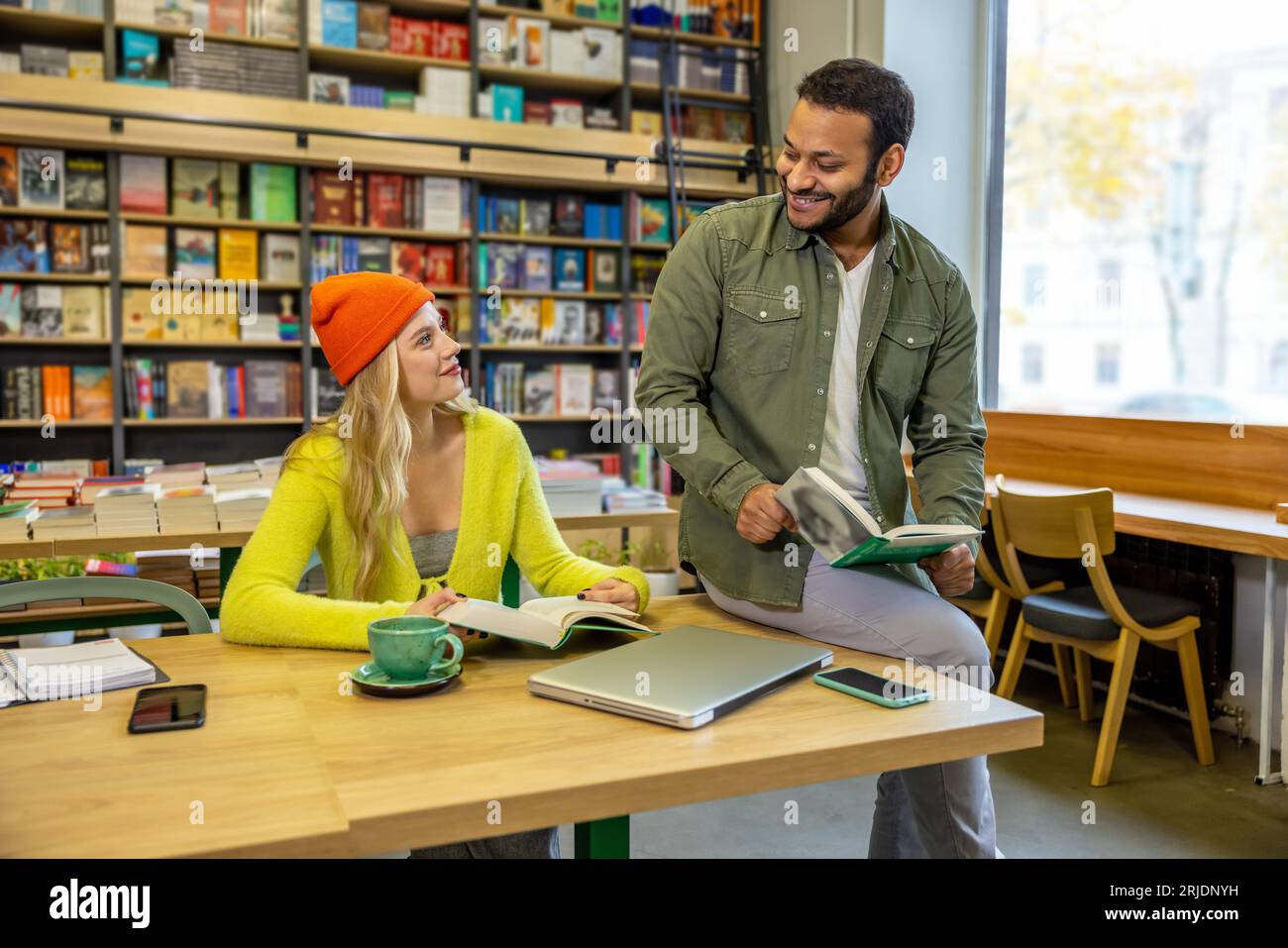 Cute woman and young man talking in the library Stock Photo - Alamy