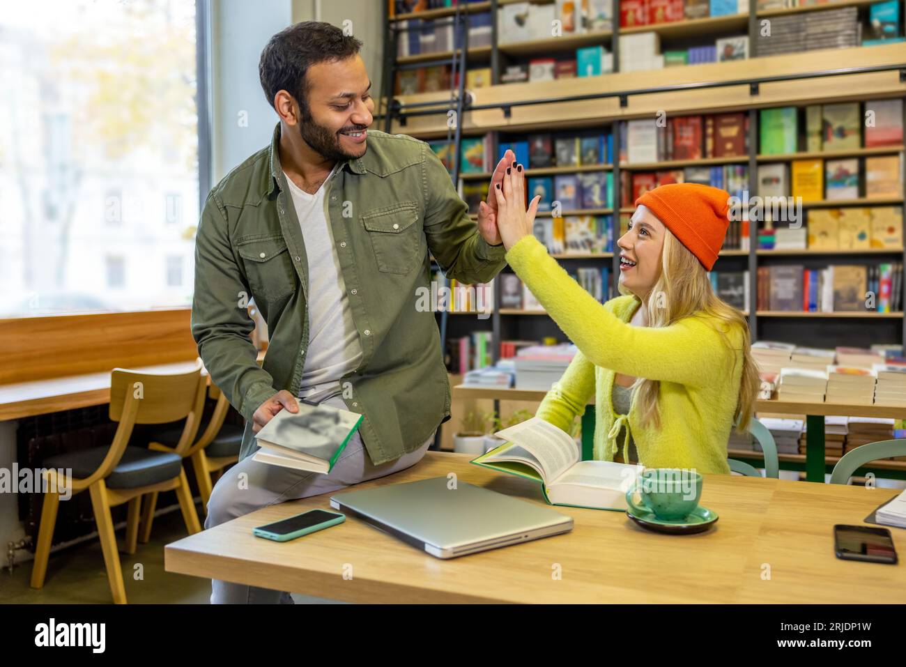 Cute woman and young man talking in the library Stock Photo - Alamy