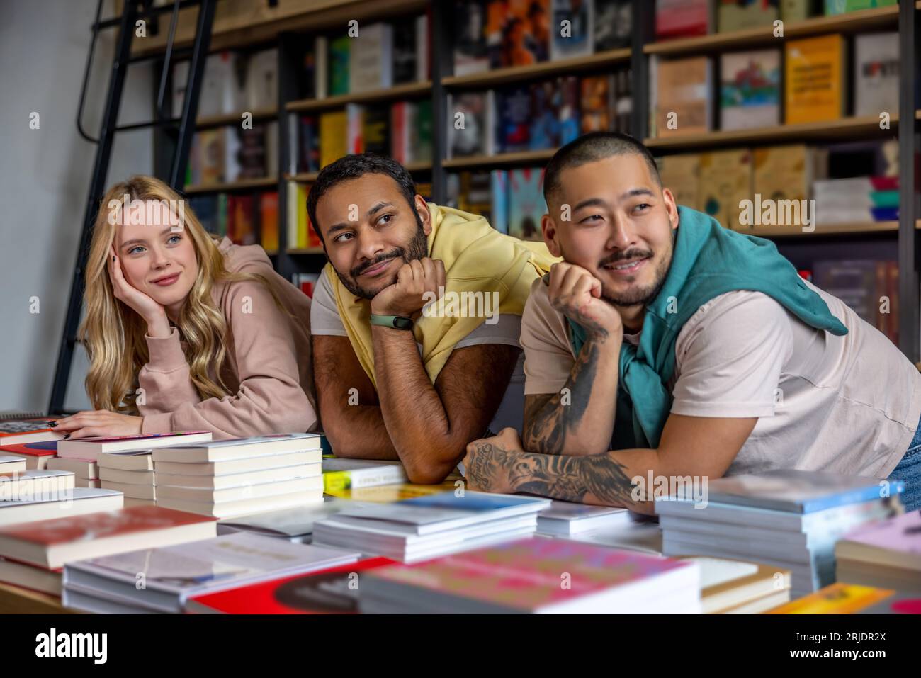Happy students sitting in the library Stock Photo - Alamy