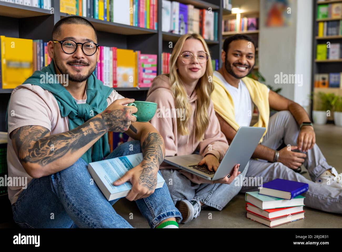 Happy students sitting in the library Stock Photo - Alamy