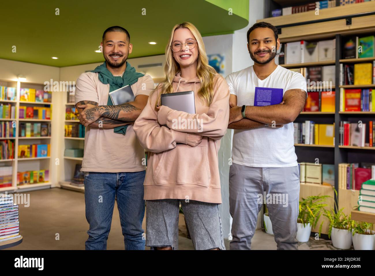 Students standing with books in library Stock Photo - Alamy