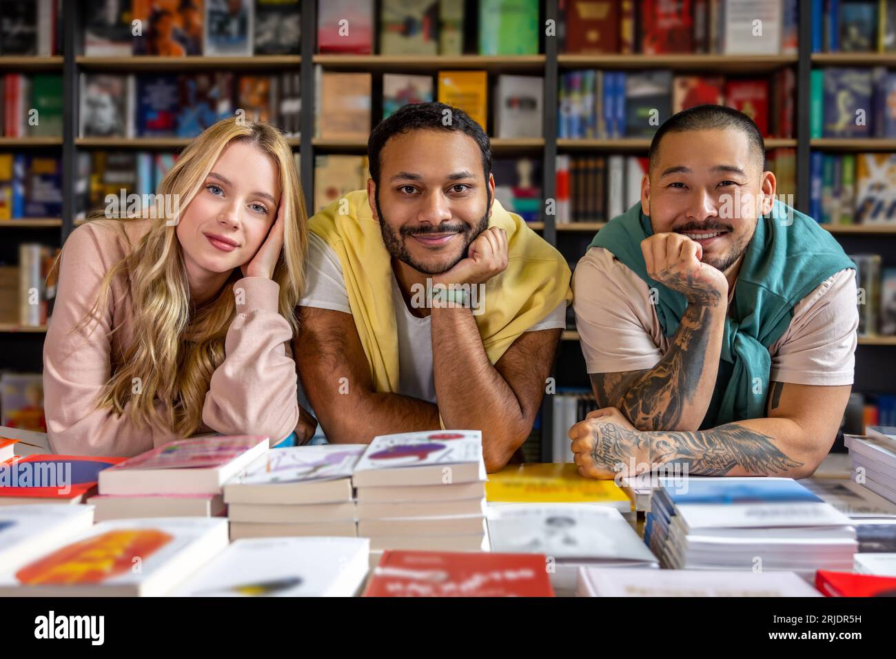 Happy students sitting in the library Stock Photo - Alamy