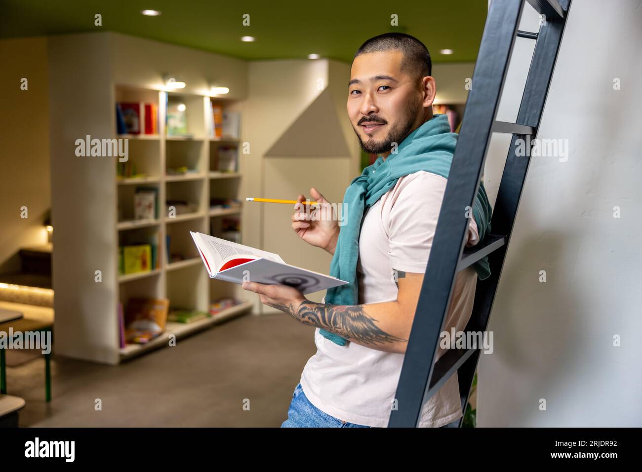 Young asian student standing next to the ladder Stock Photo - Alamy