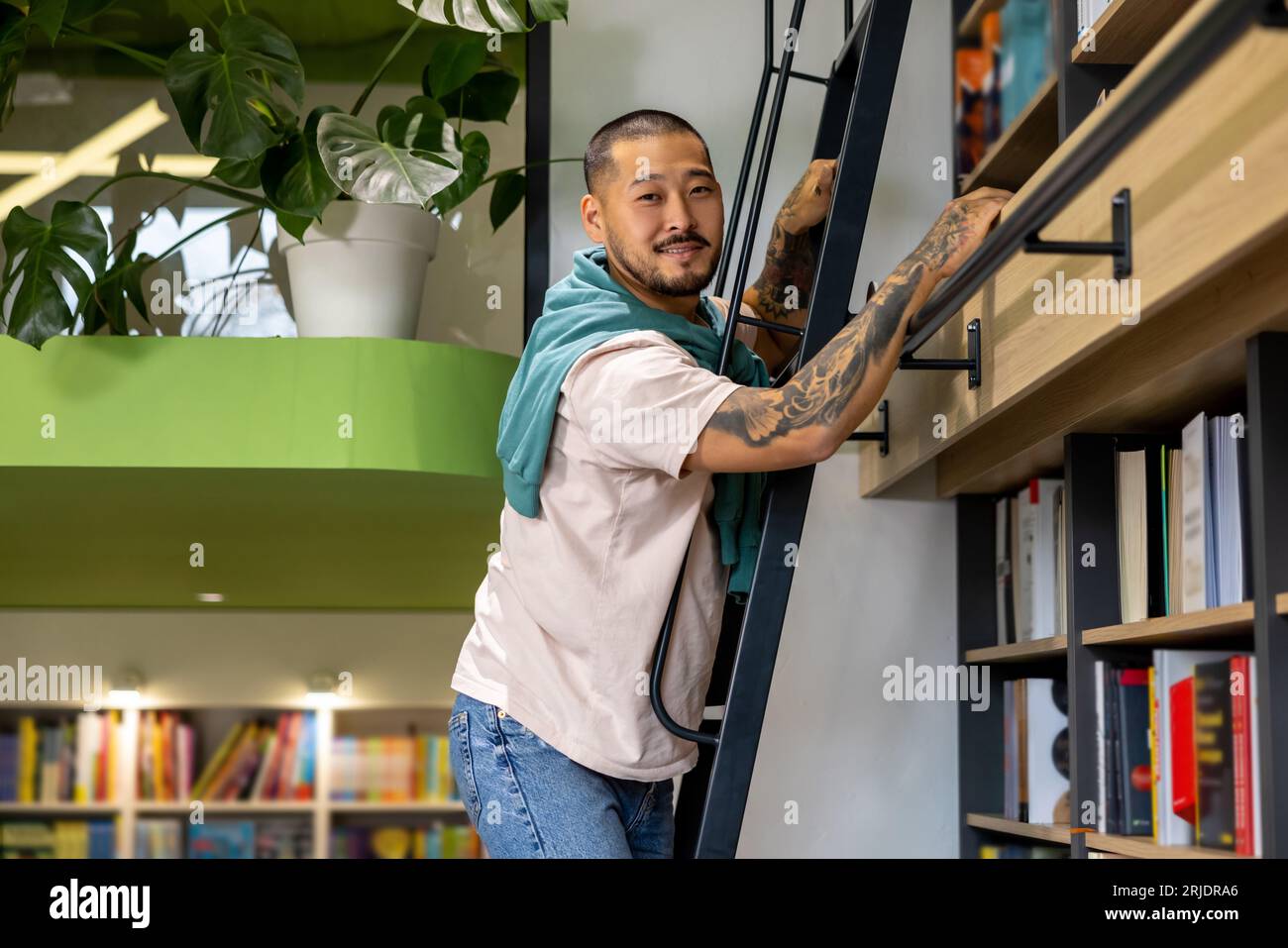 Young asian student standing next to the ladder Stock Photo - Alamy