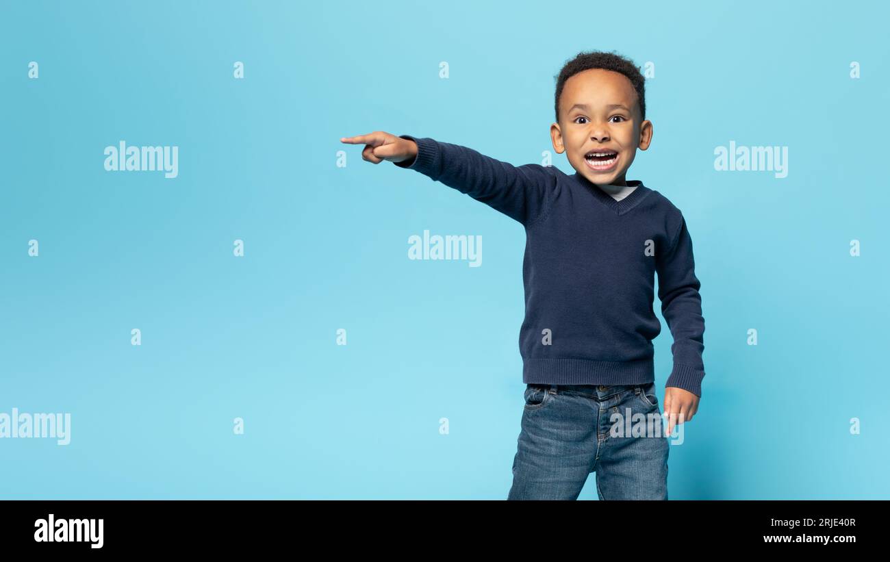 Funny african american boy pointing aside at copy space, emotional male ...