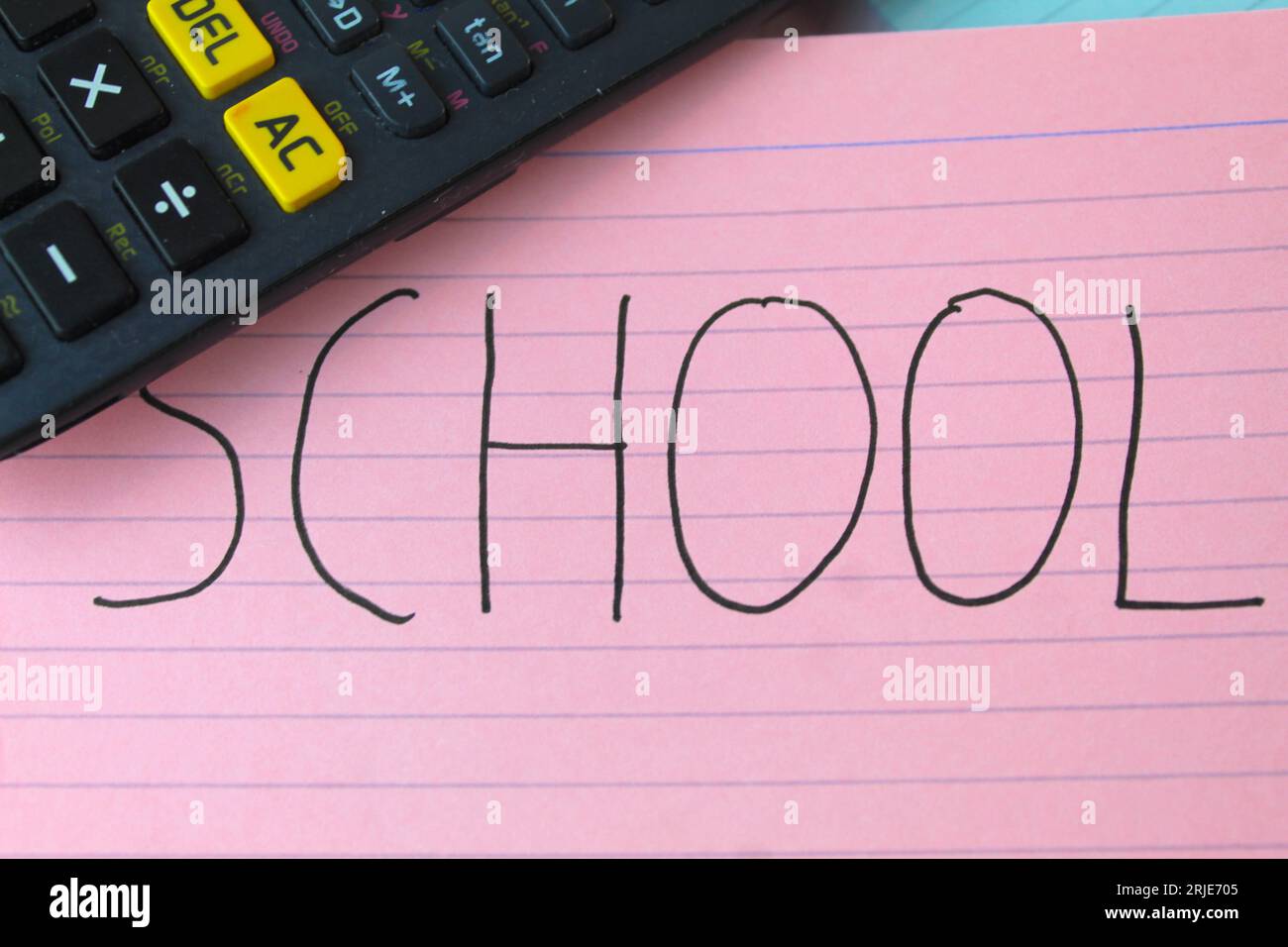 A photo of the word 'School' written on a pink flashcard in black ...