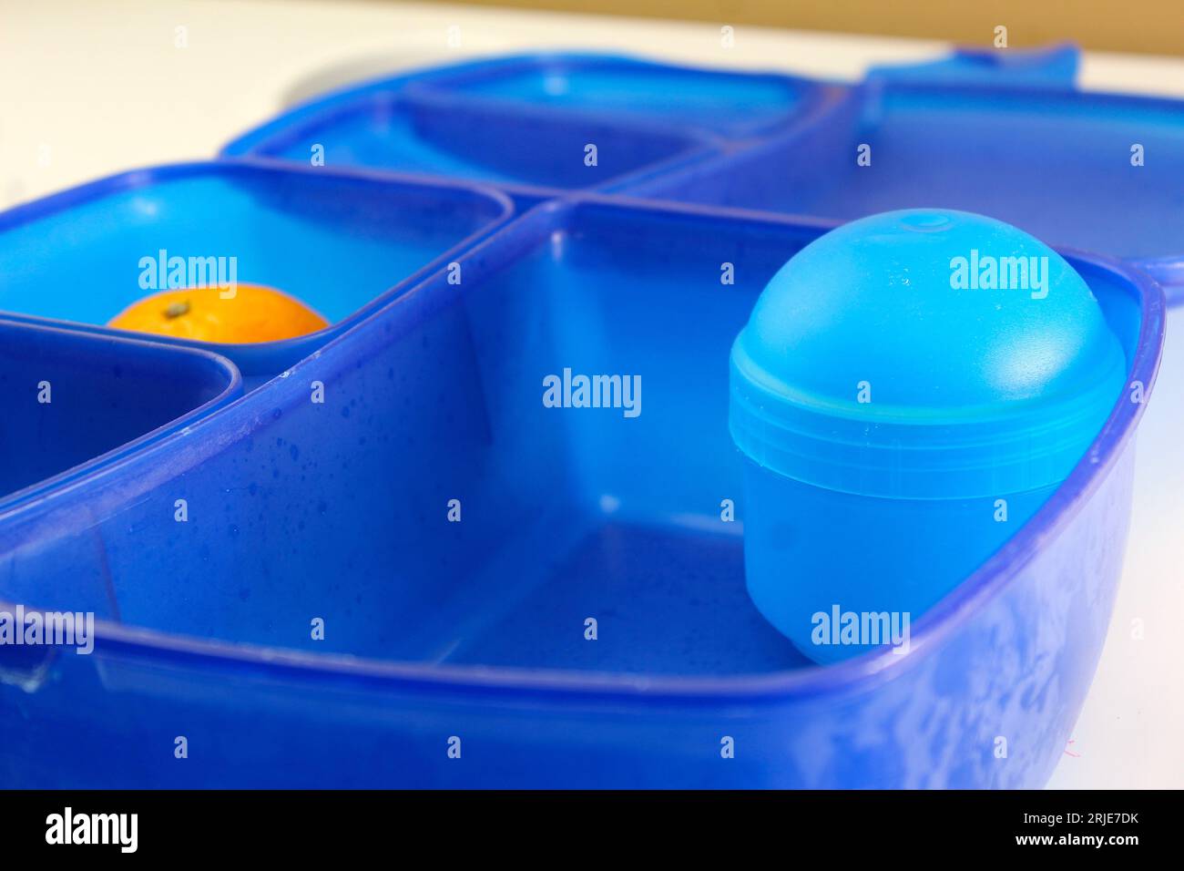 A photo of a blue lunchbox for a school student with an orange in it ...