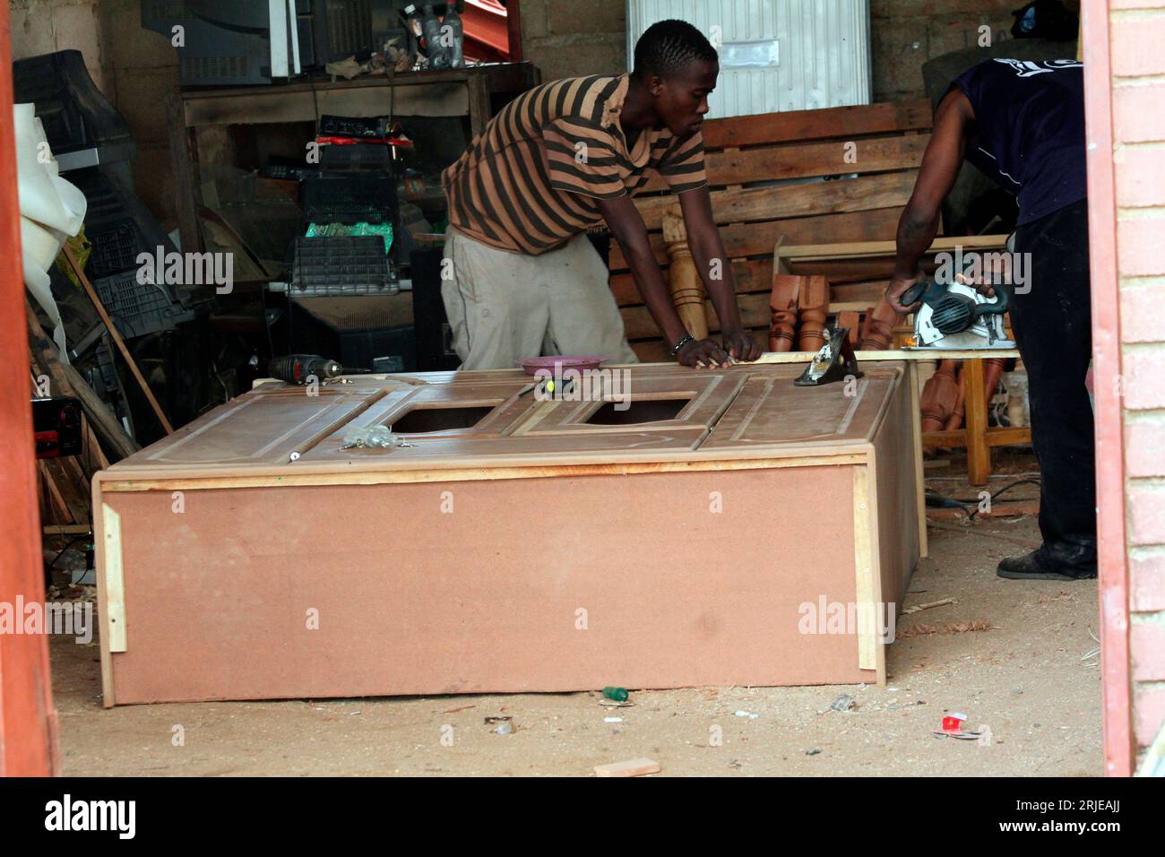 A carpenter making a wardrobe in his shop at a shopping centre in ...