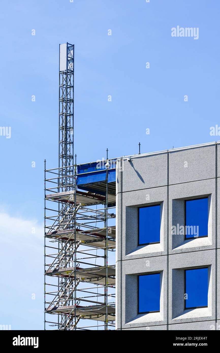 Repair works of a modern office building using portable scaffolding ...