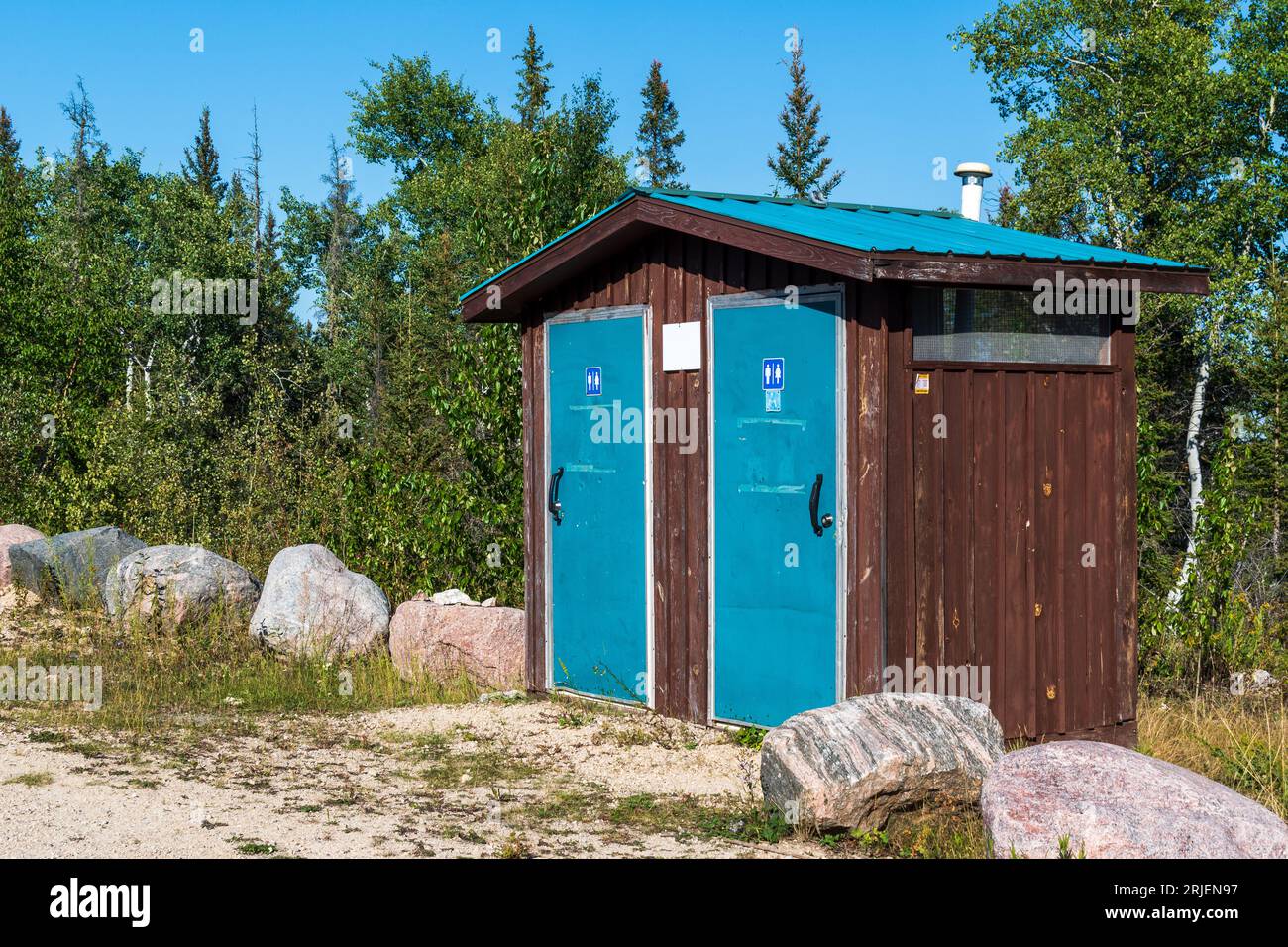 Blue restroom outhouse, rocks, against trees forest background Stock ...