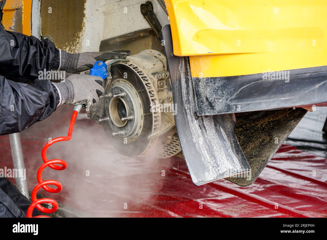 Rally car maintenance in service park, blowing off dust from the brake ...