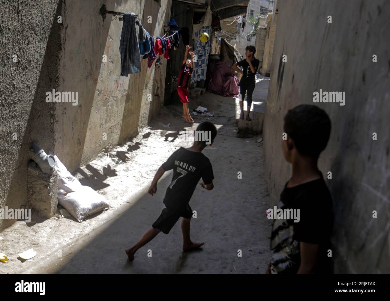 Palestinian children play football outside their home in Al-Shati ...