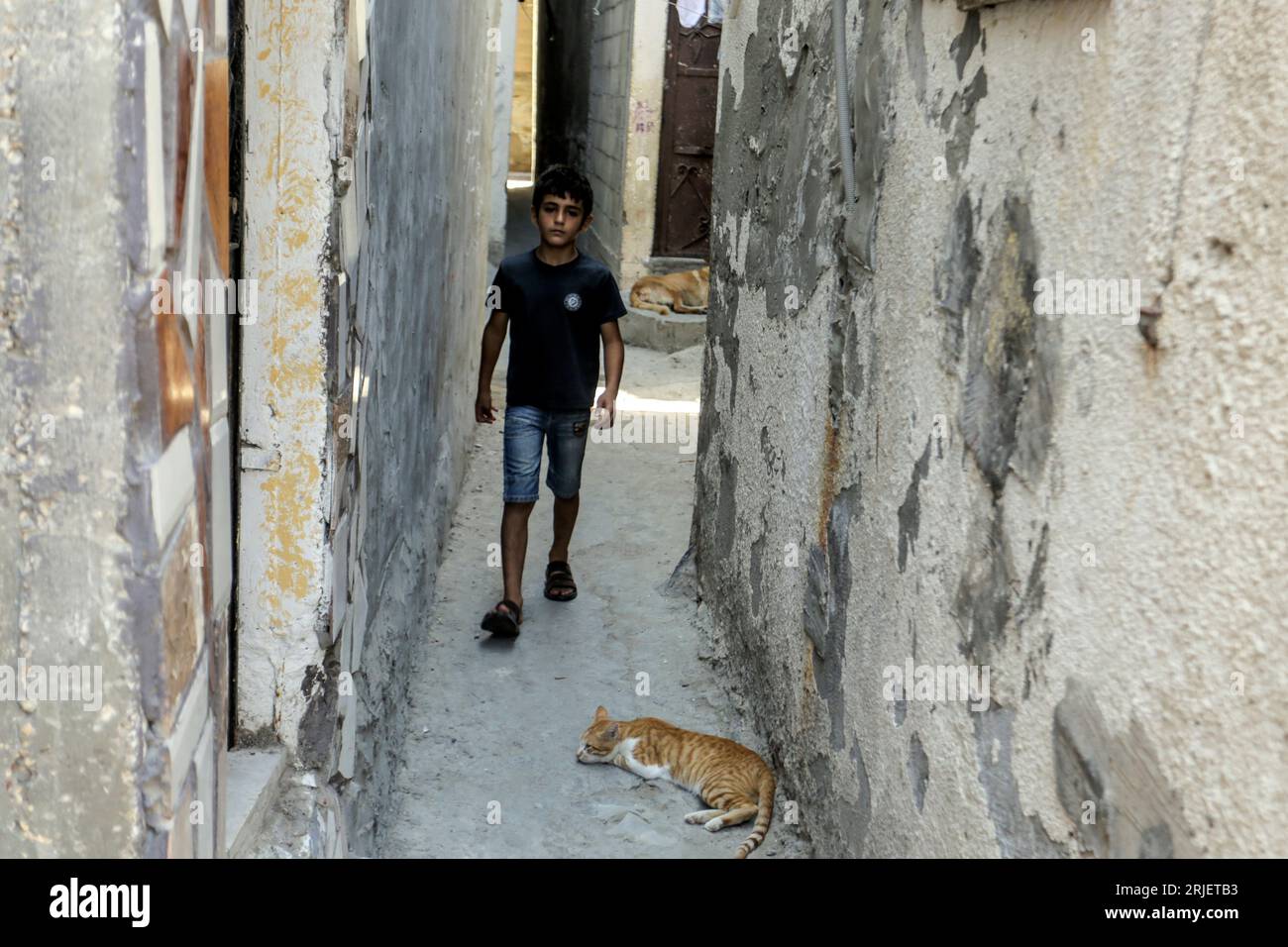A Palestinian child walks outside his home in Al-Shati refugee camp ...