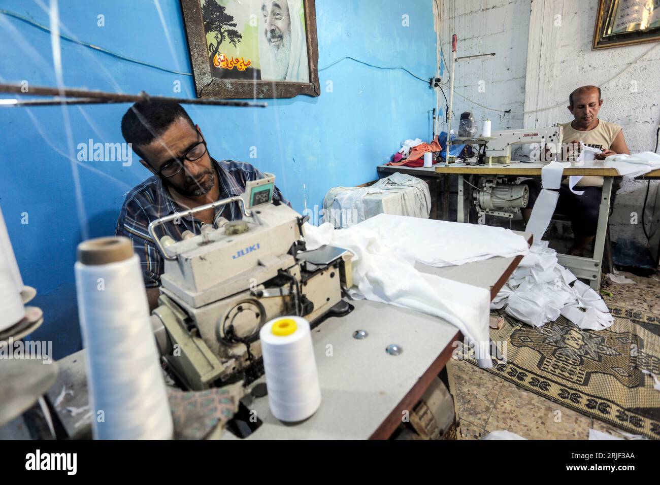Gaza City, Palestine. 22nd Aug, 2023. Palestinian tailors sew school ...