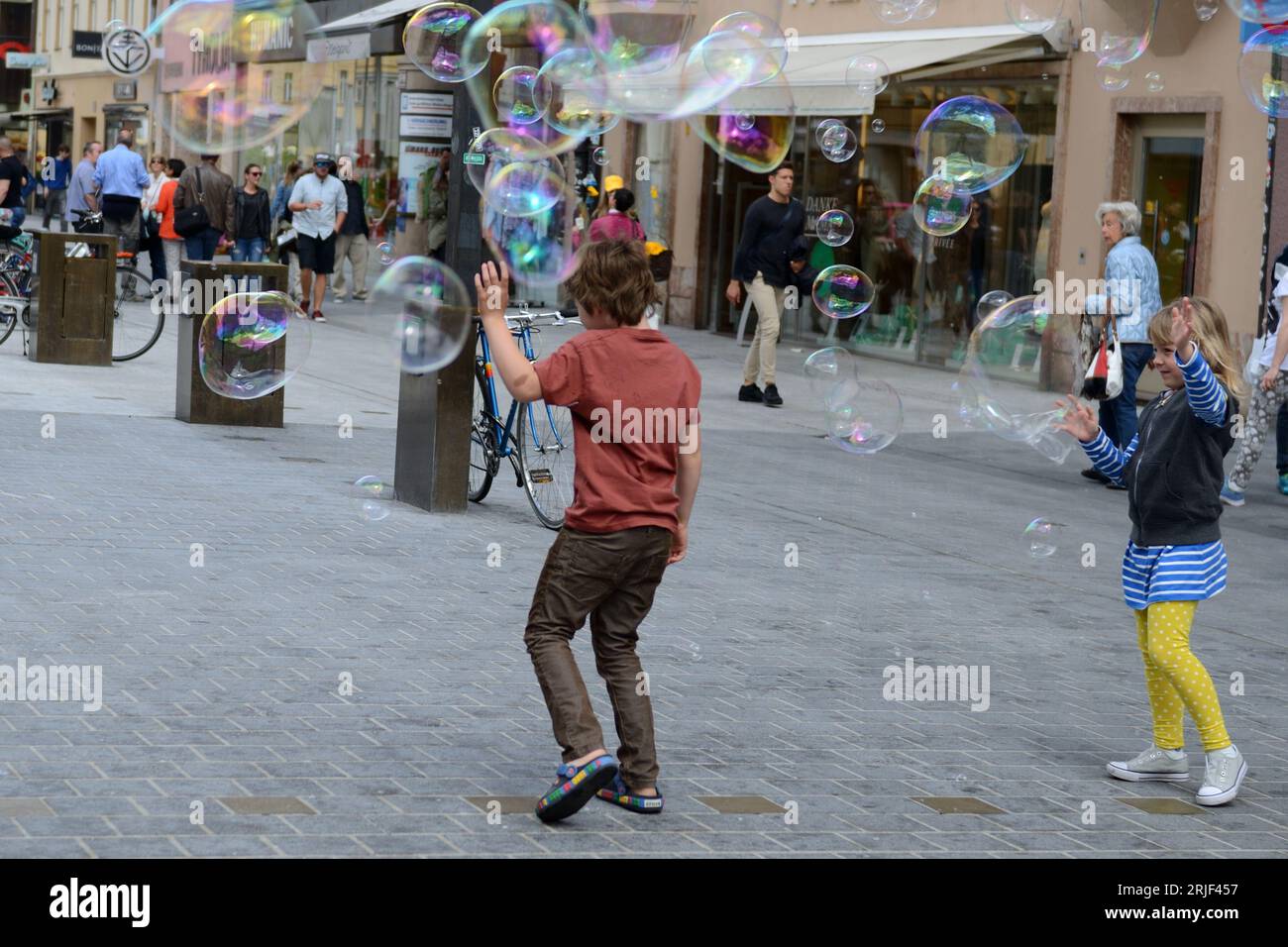 Children playing with multi bubbles on the streets of Innsbruck Stock ...