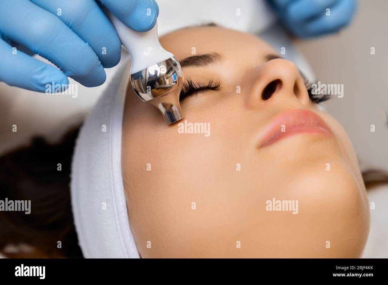 Spa worker makes face massage to woman for rejuvenation with appliance ...
