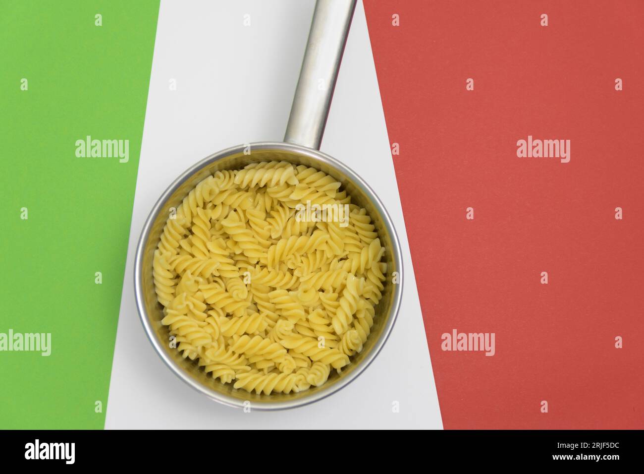 Pasta in saucepan on the green red white background. close up. Italian ...