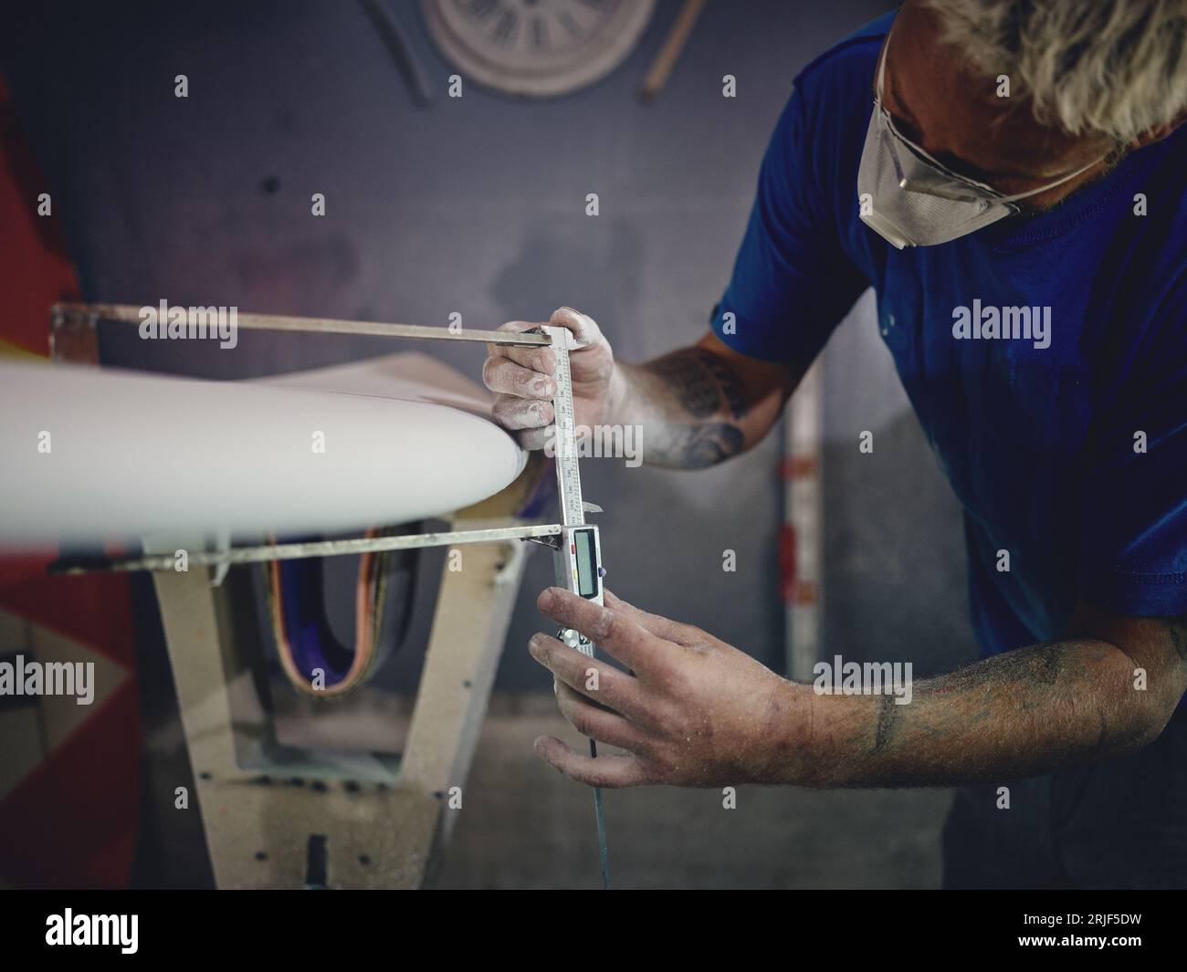 Crop attentive male shaper with blond hair and tattoos on arms in ...