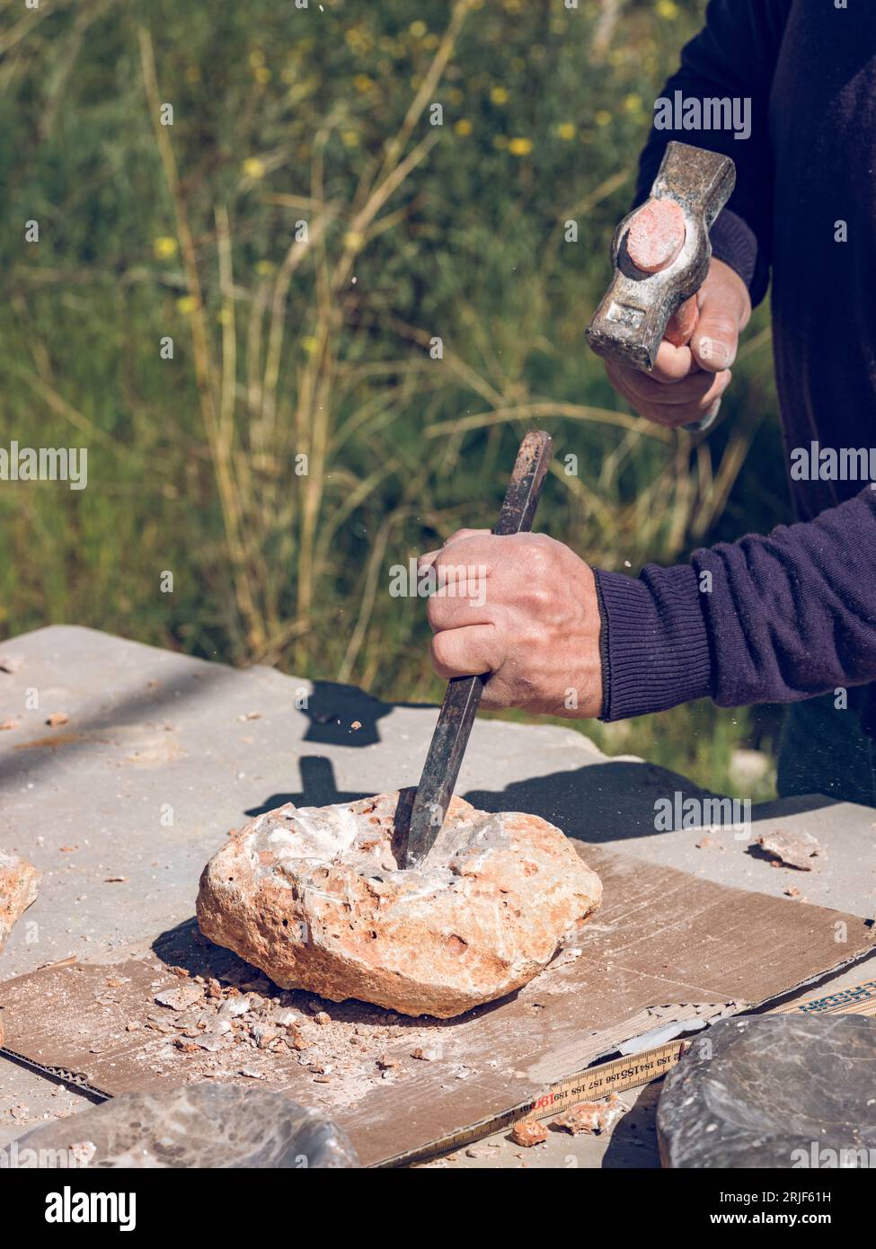 From above of crop anonymous craftsman cutting solid rock using sharp ...