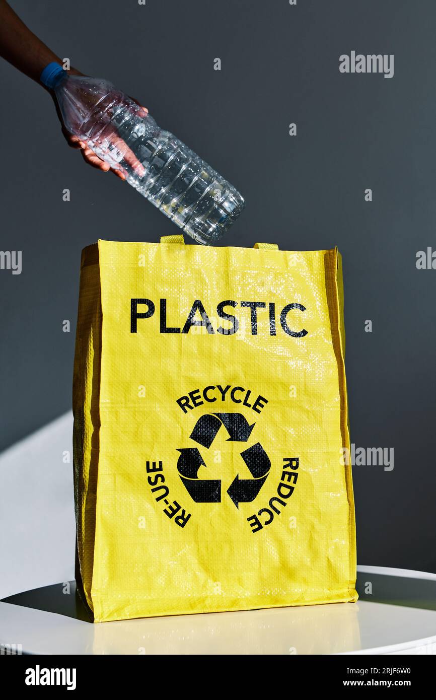 Crop anonymous conscious female sorting garbage and putting plastic bag ...