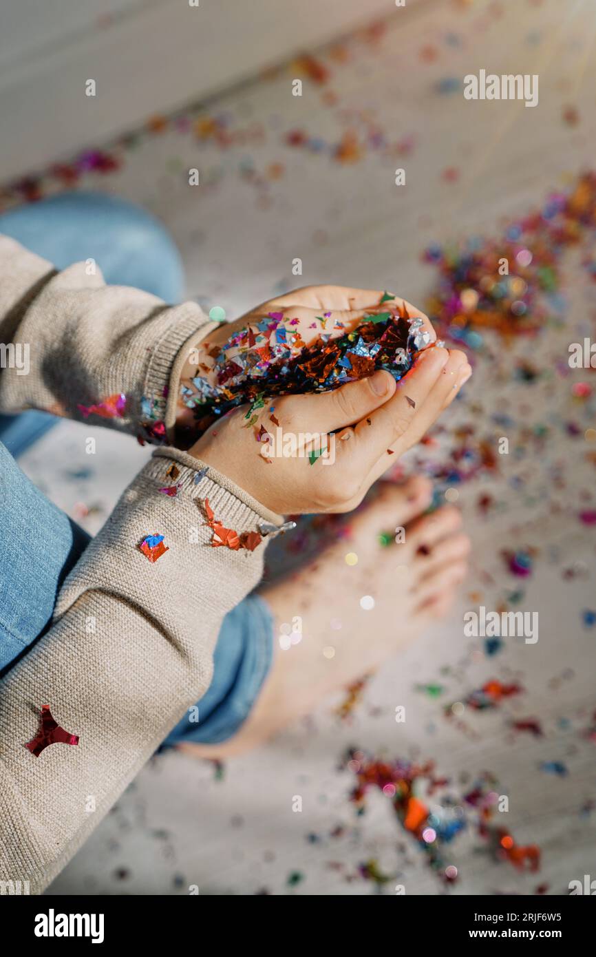High angle of crop anonymous barefoot boy sitting on floor with ...