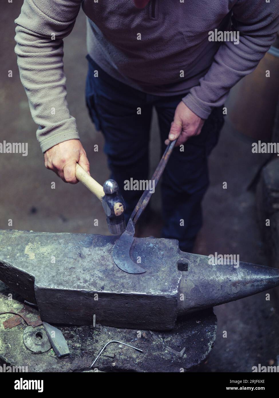 From above of crop unrecognizable male blacksmith in casual clothes ...