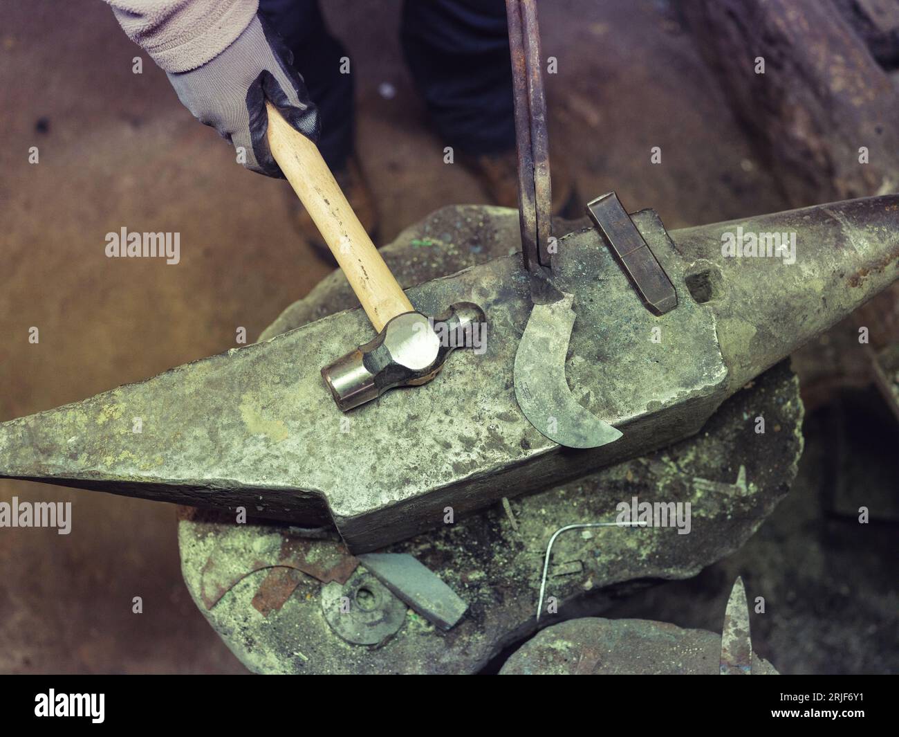 From above of crop anonymous blacksmith in protective gloves using ...