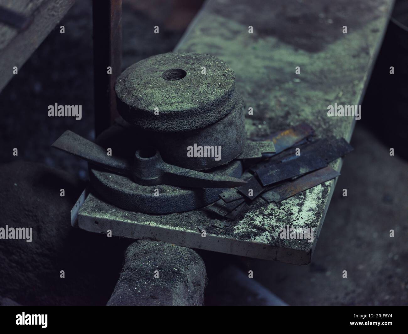 High angle of metal grinding wheel and part of pickaxe placed on dusty ...