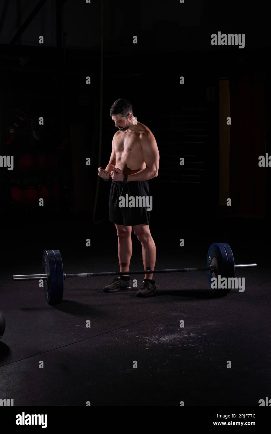 Full body of muscular male athlete preparing for doing deadlift with ...