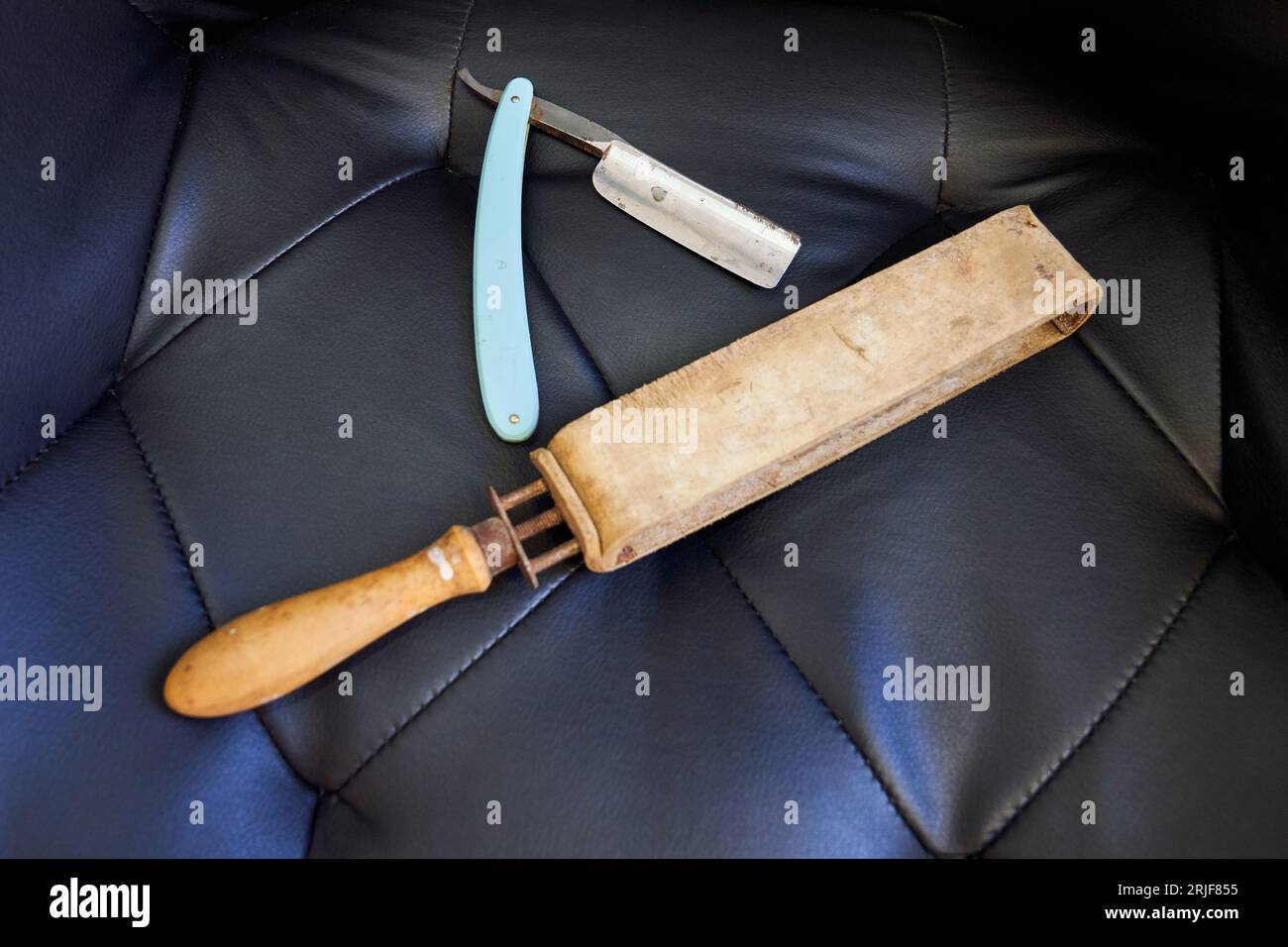 From above of dangerous razor and retro adjustable razor strop placed ...