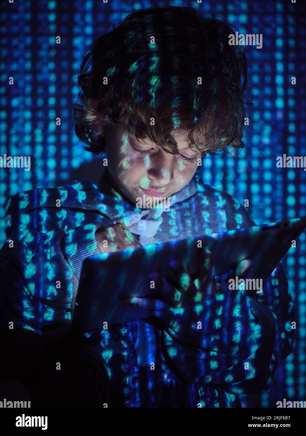 Teen programmer boy in hoodie using digital tablet for malware coding ...