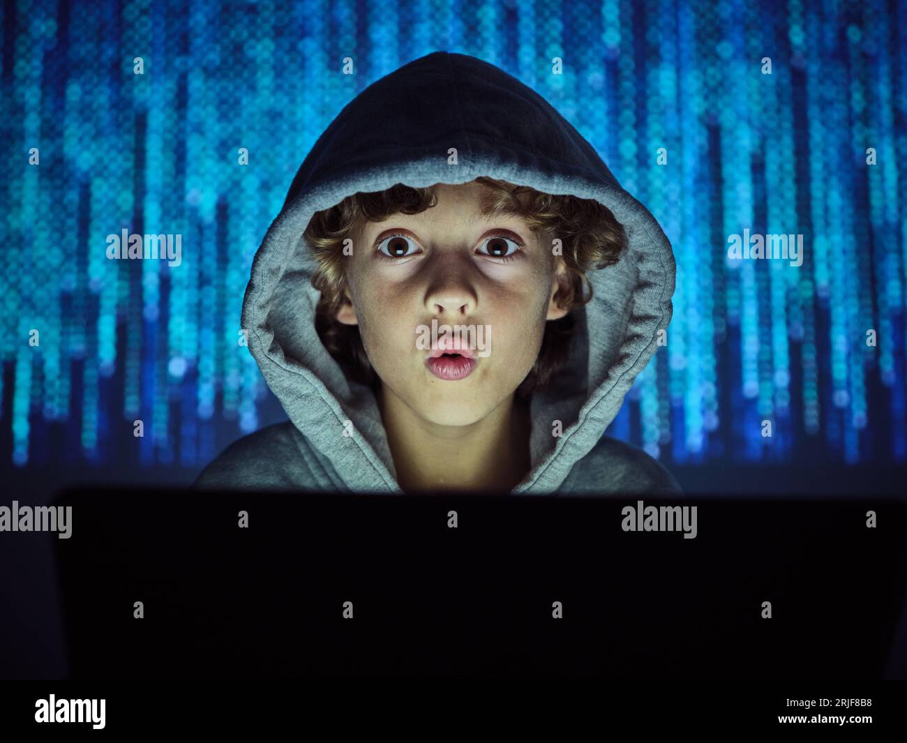 Amazed preteen programmer kid with laptop on blurred binary code ...