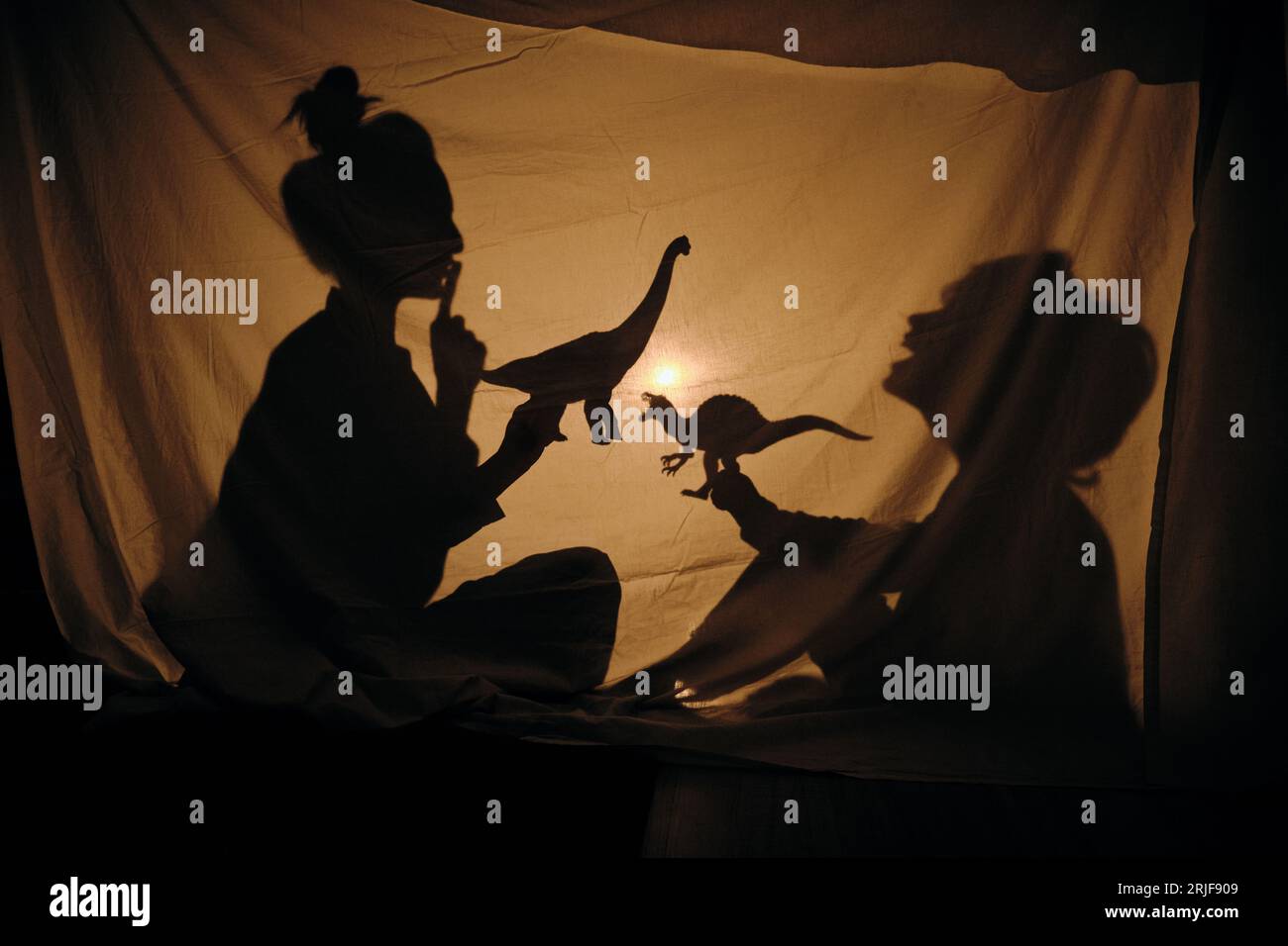 Side view of mom showing shh gesture while playing with son with ...