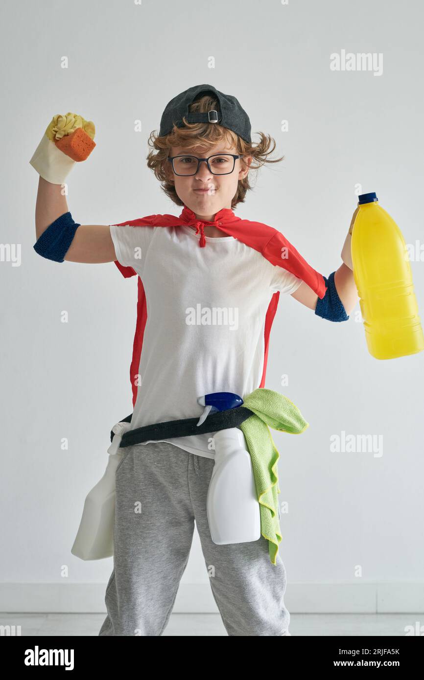 Positive preteen boy smiling and looking at camera while standing in ...